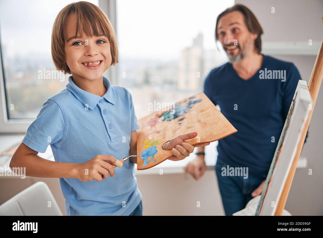 Cheerful little boy and his dad making a painting Stock Photo - Alamy