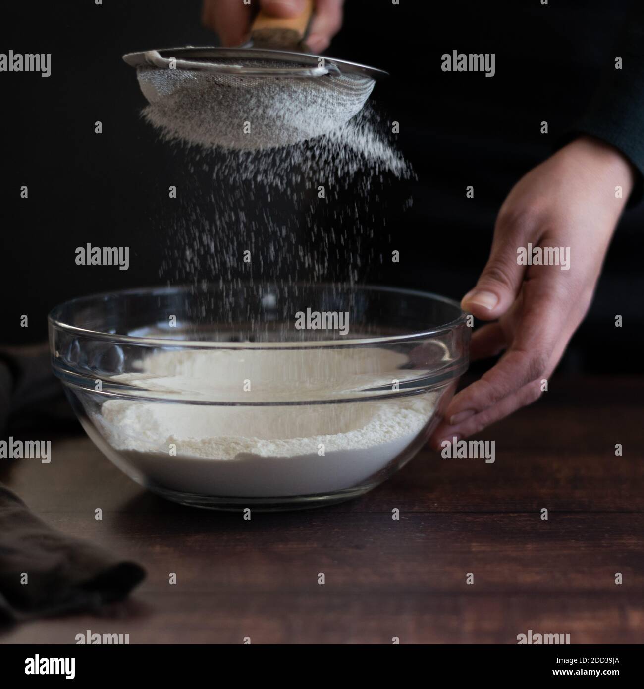 Crop view of woman hands sifting flour through sieve Stock Photo - Alamy