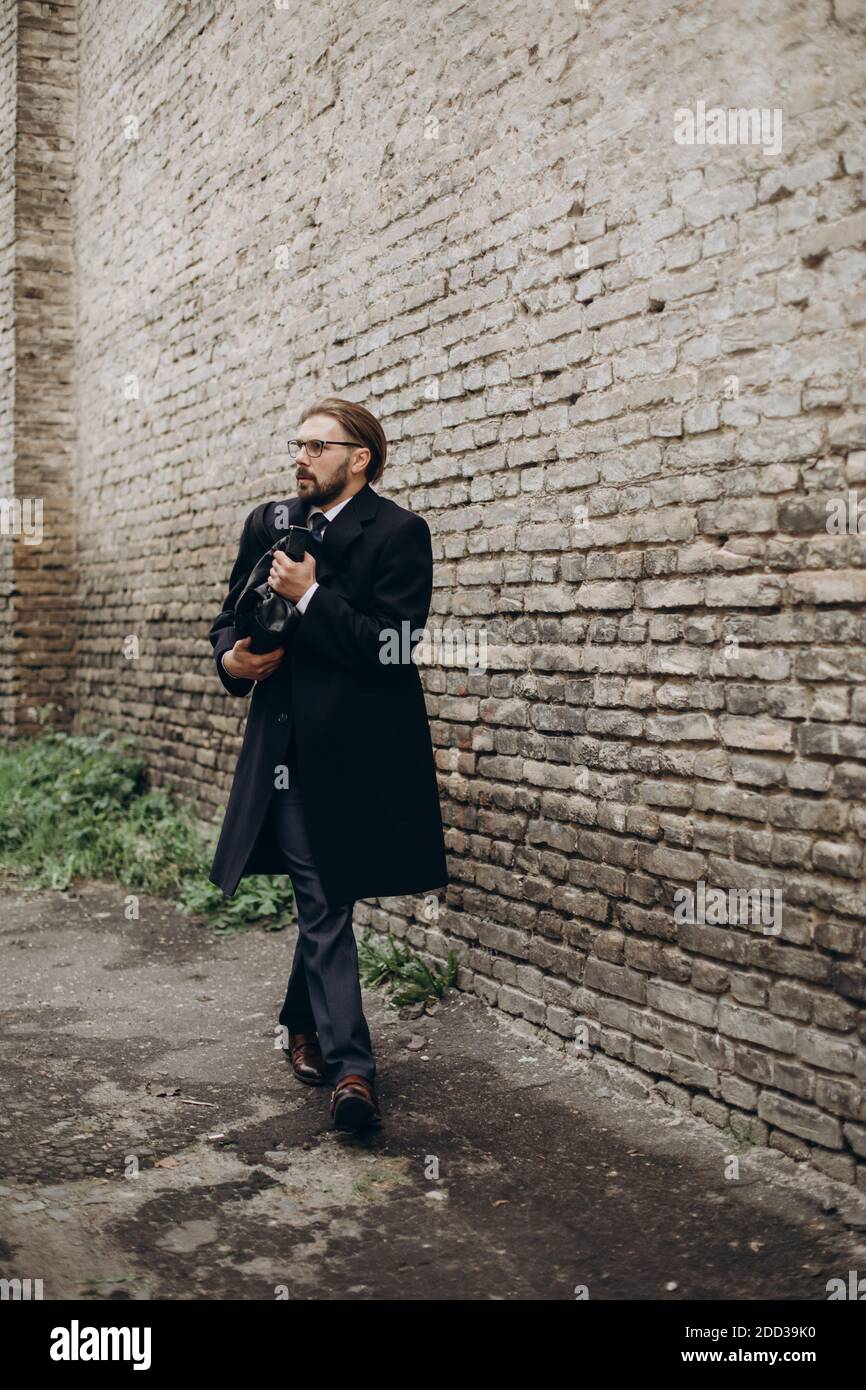 Scared man embracing bag while walking outdoors Stock Photo - Alamy