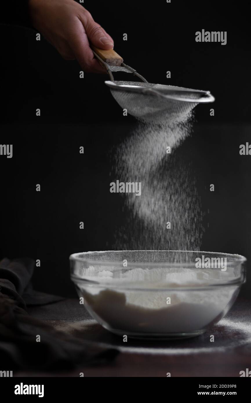 Crop view of woman hands sifting flour through sieve Stock Photo - Alamy