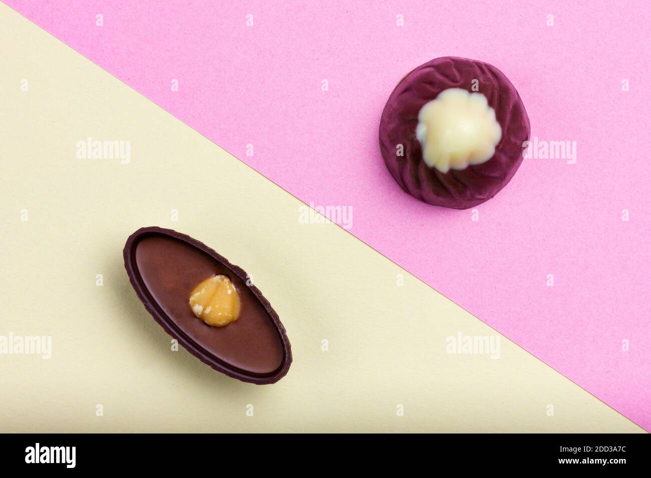 Two chocolates on a pink yellow diagonal background Stock Photo - Alamy