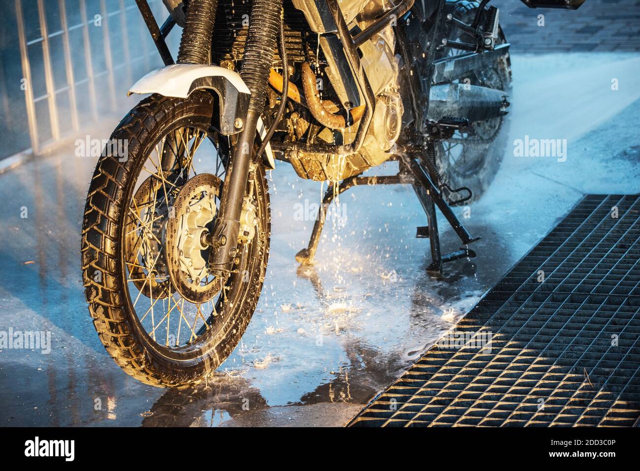 Motorbike washing series. Washing a motorcycle at a car wash at sunset ...