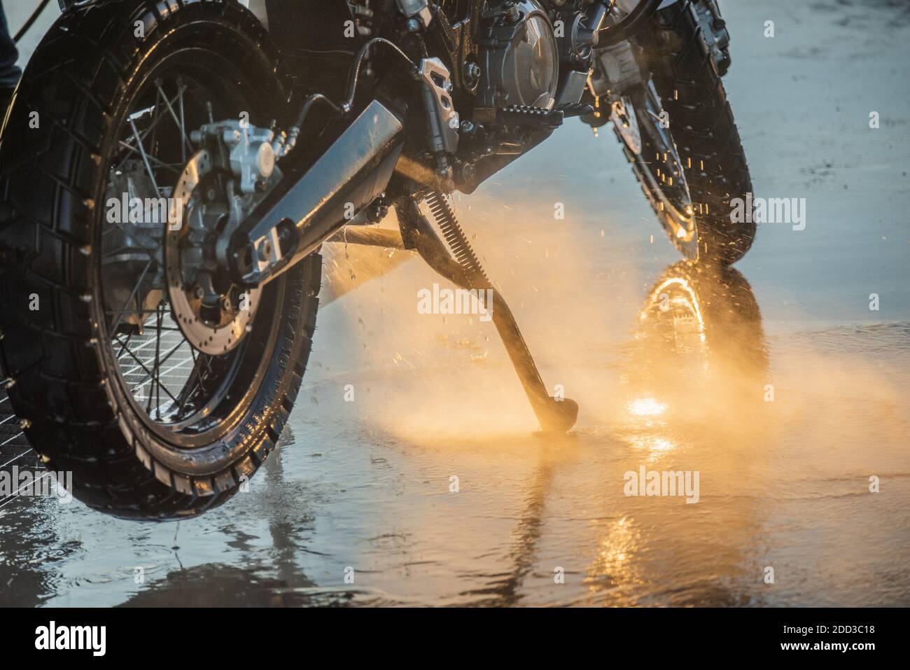 Motorbike washing series. Washing a motorcycle at a car wash at sunset ...
