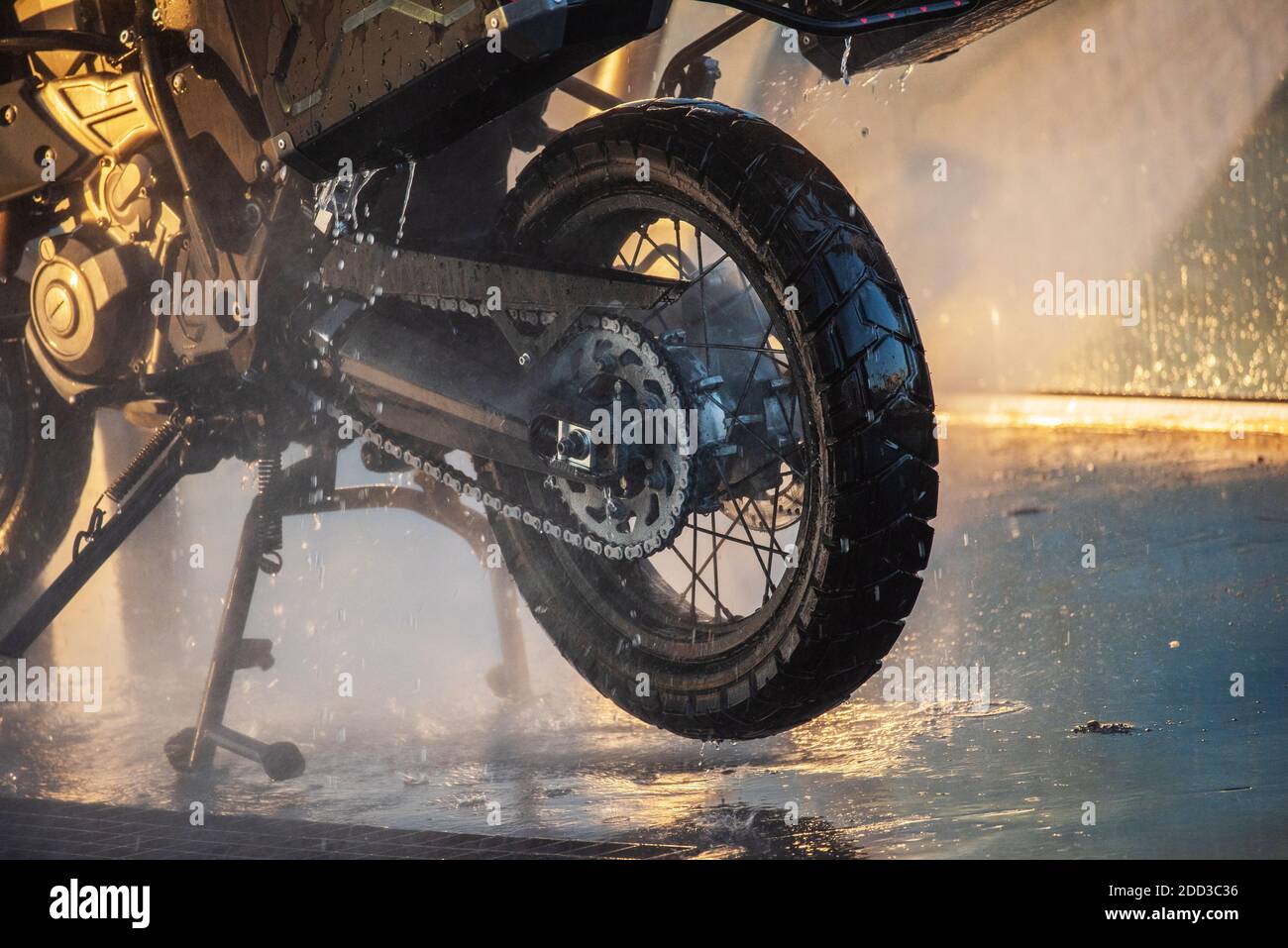 Motorbike washing series. Washing a motorcycle at a car wash at sunset ...