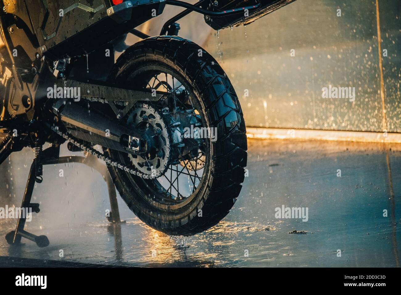 Motorbike washing series. Washing a motorcycle at a car wash at sunset ...