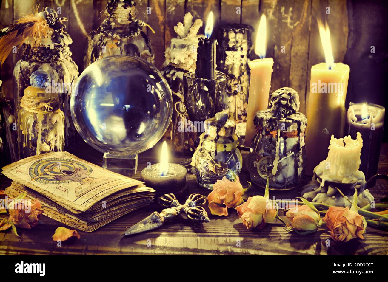 Magic crystal ball, witch bottles and burning candles on the wooden ...