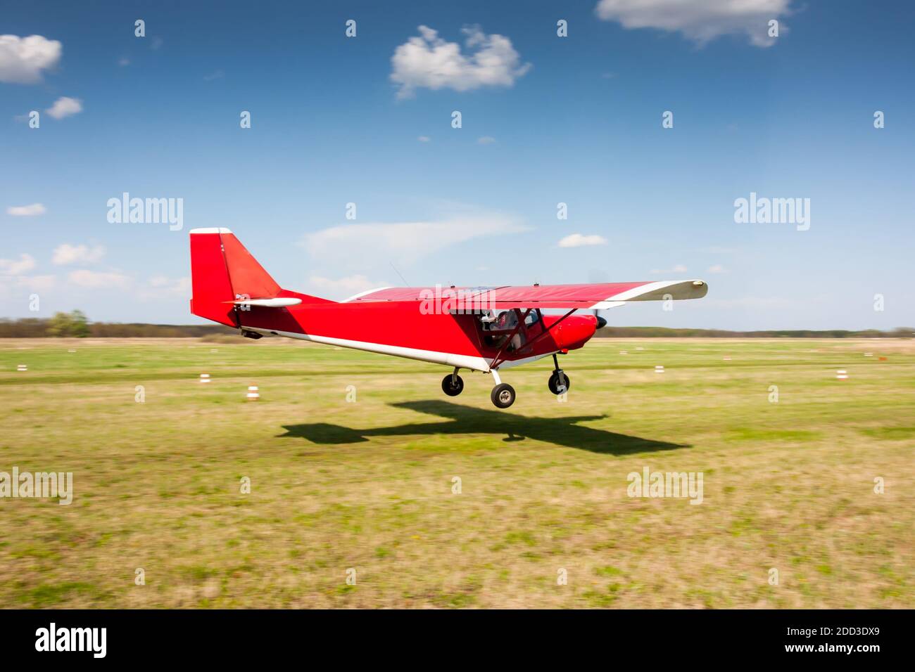 Landing red small private aircraft on the airfield Stock Photo - Alamy