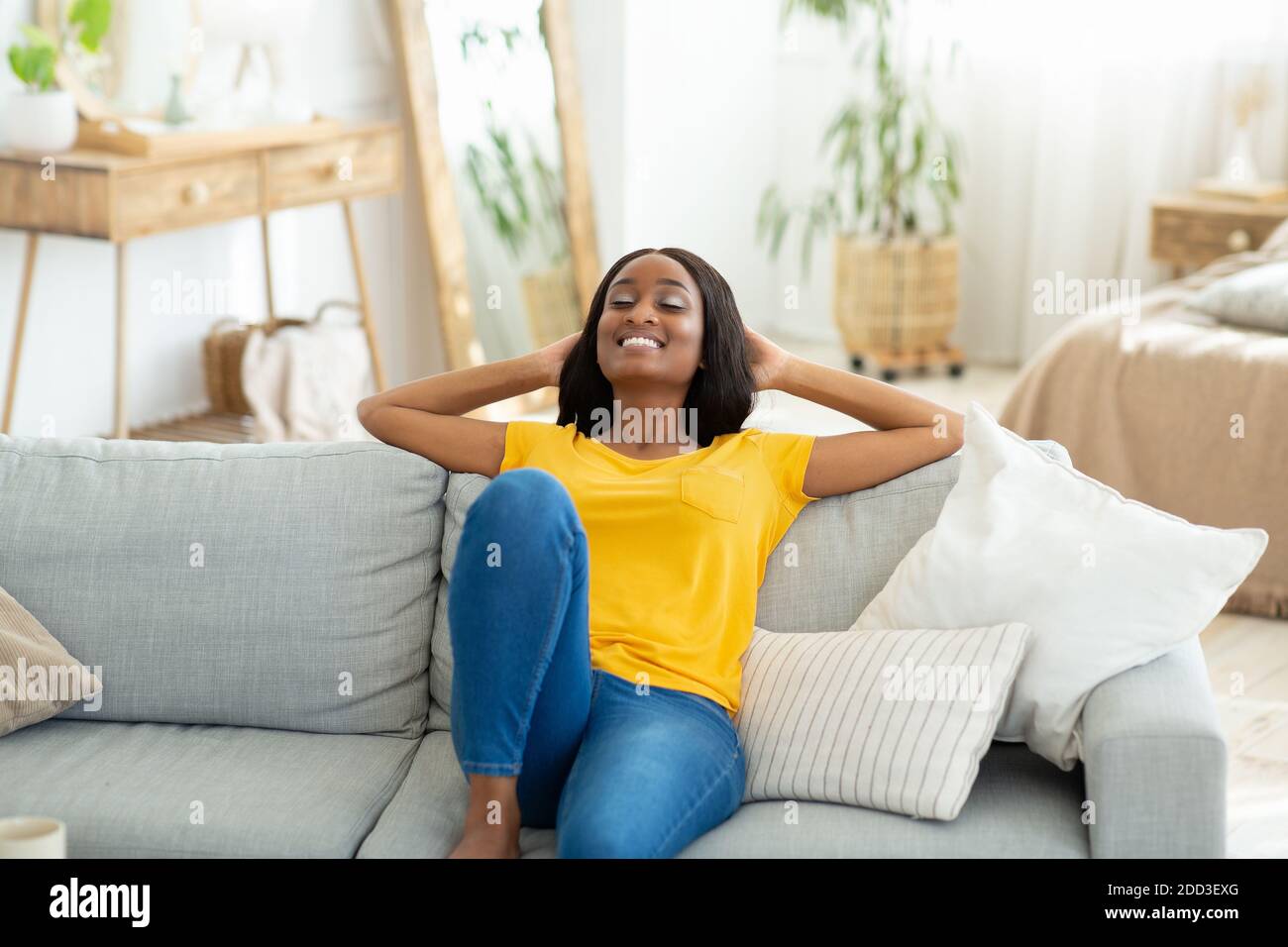 Happy black woman relaxing on cozy sofa at home, having peaceful time ...