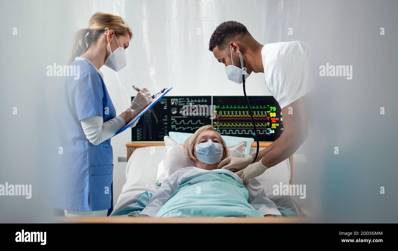 Doctors and covid-19 infected patient in bed in hospital, coronavirus ...