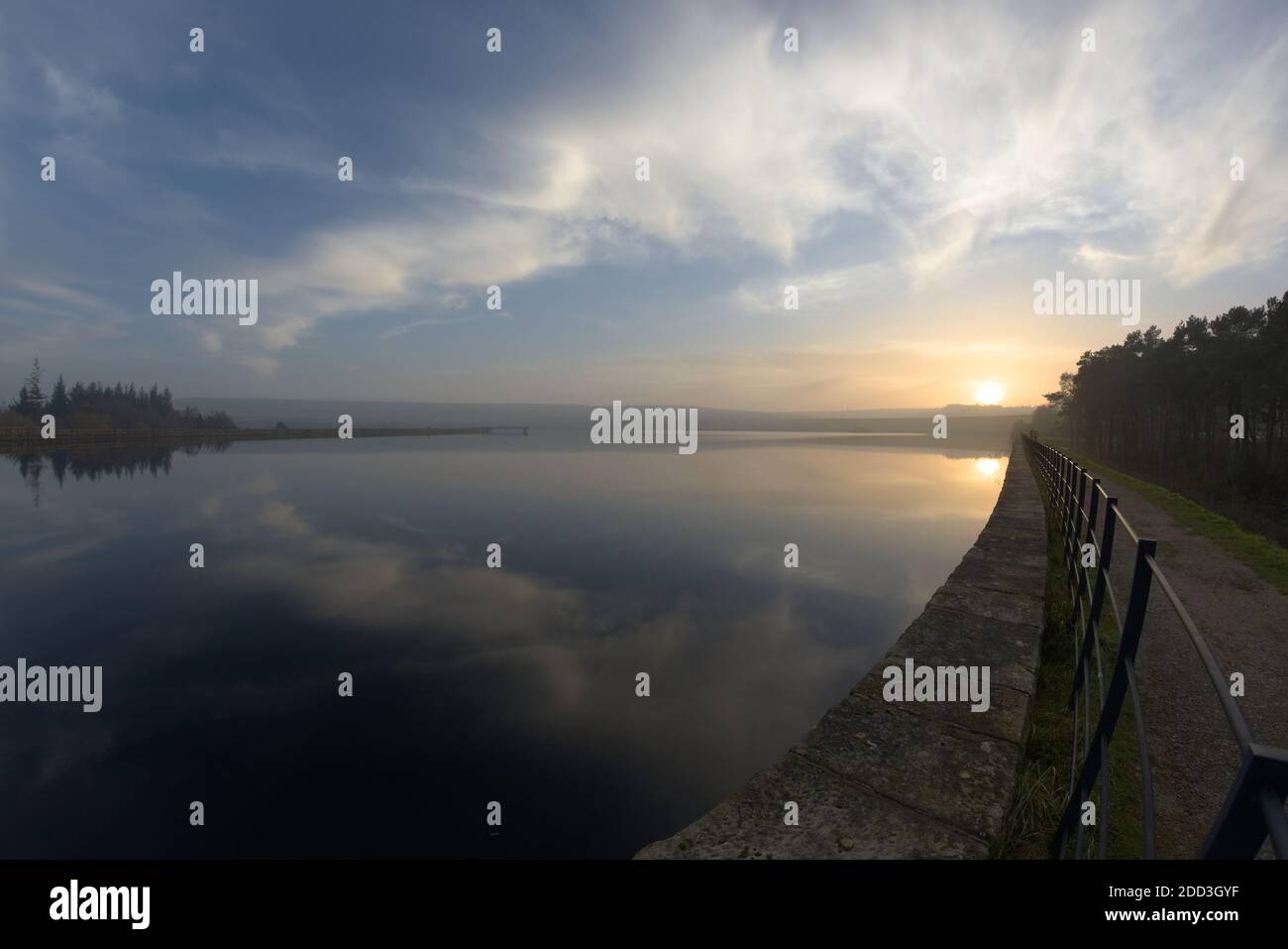 Sunset and clouds reflected in the water of redmires reservoir near ...