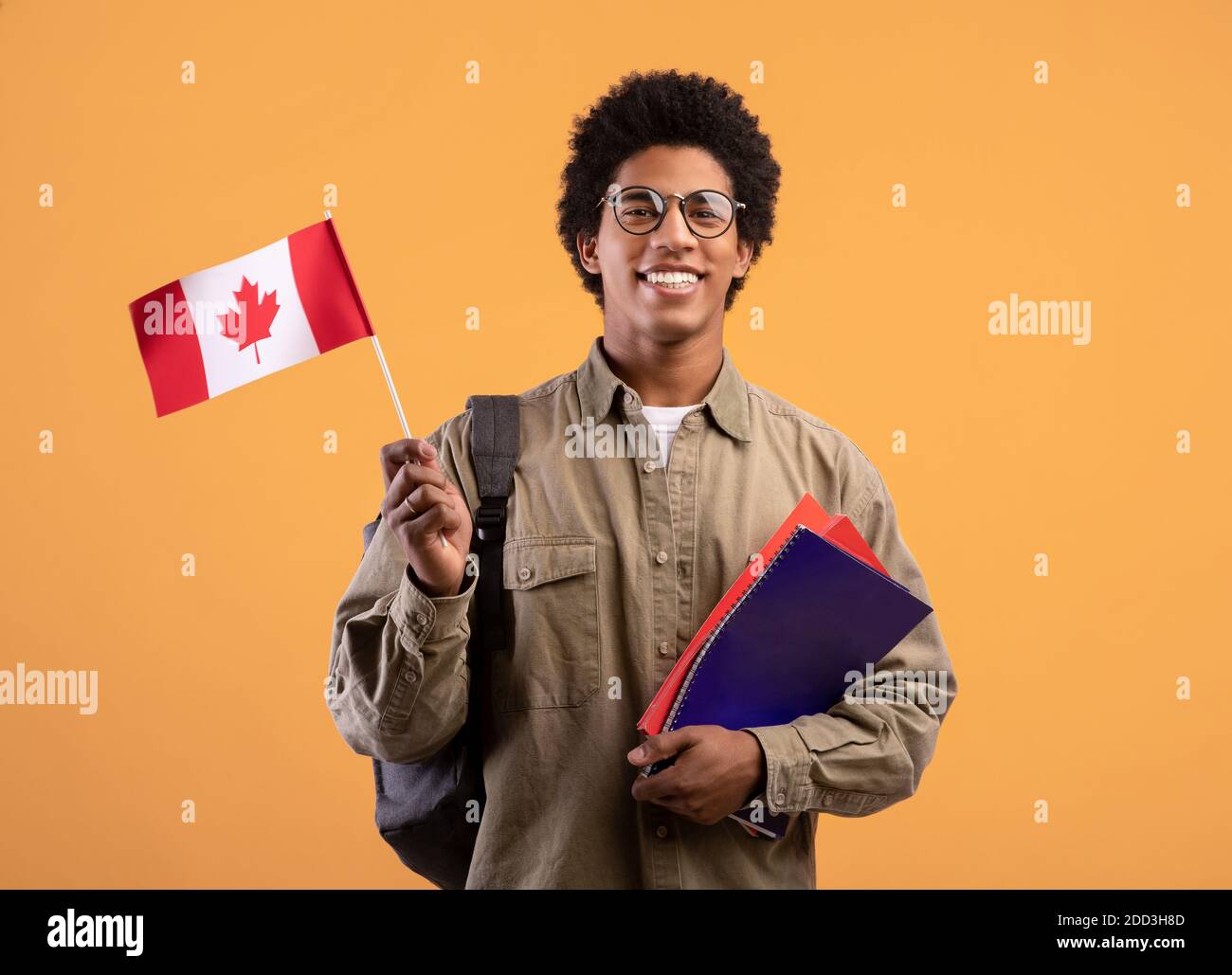 Happy young african american guy in glasses holding notepads and small ...