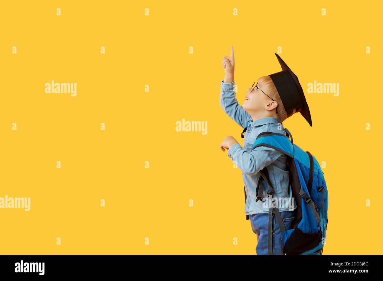 Child boy primary school student in a graduate cap, glasses and with a ...