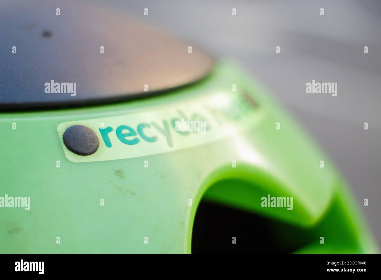 Green plastic recycle bin up-close in the street Stock Photo - Alamy