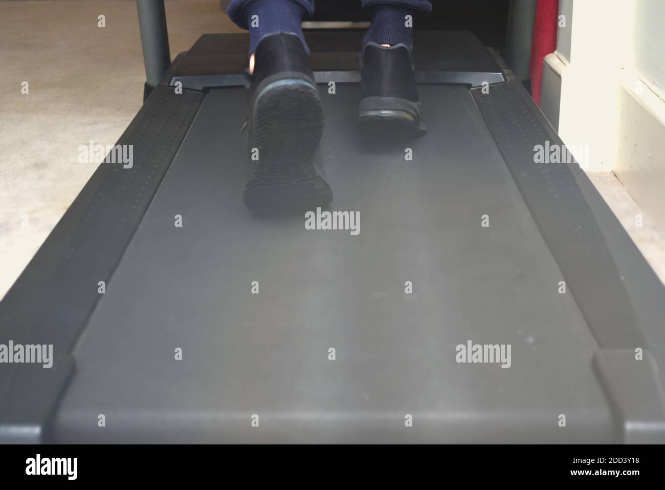Man working out at home by running on a treadmill in converted gym room ...