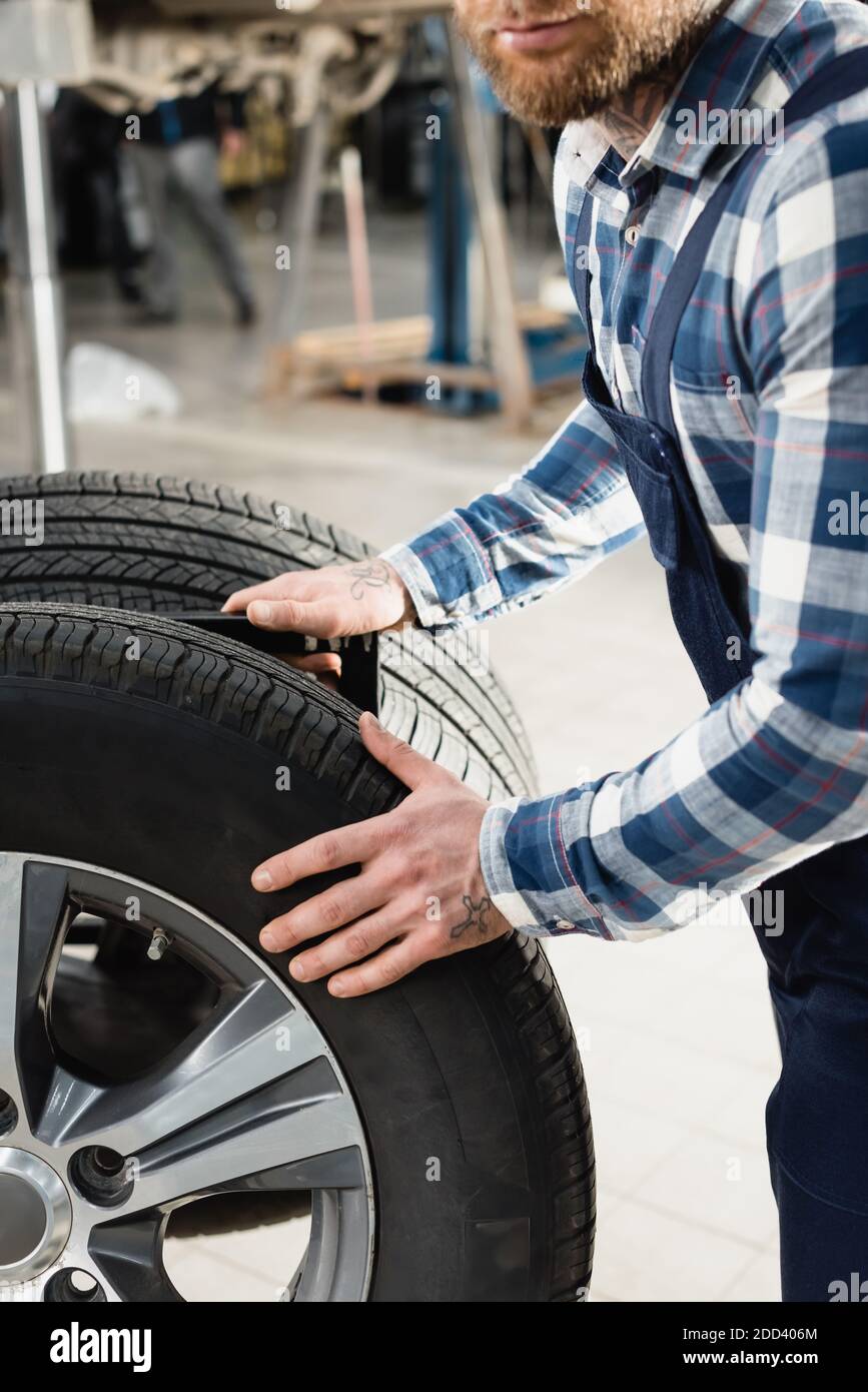 partial view of man taking car wheel in workshop Stock Photo - Alamy