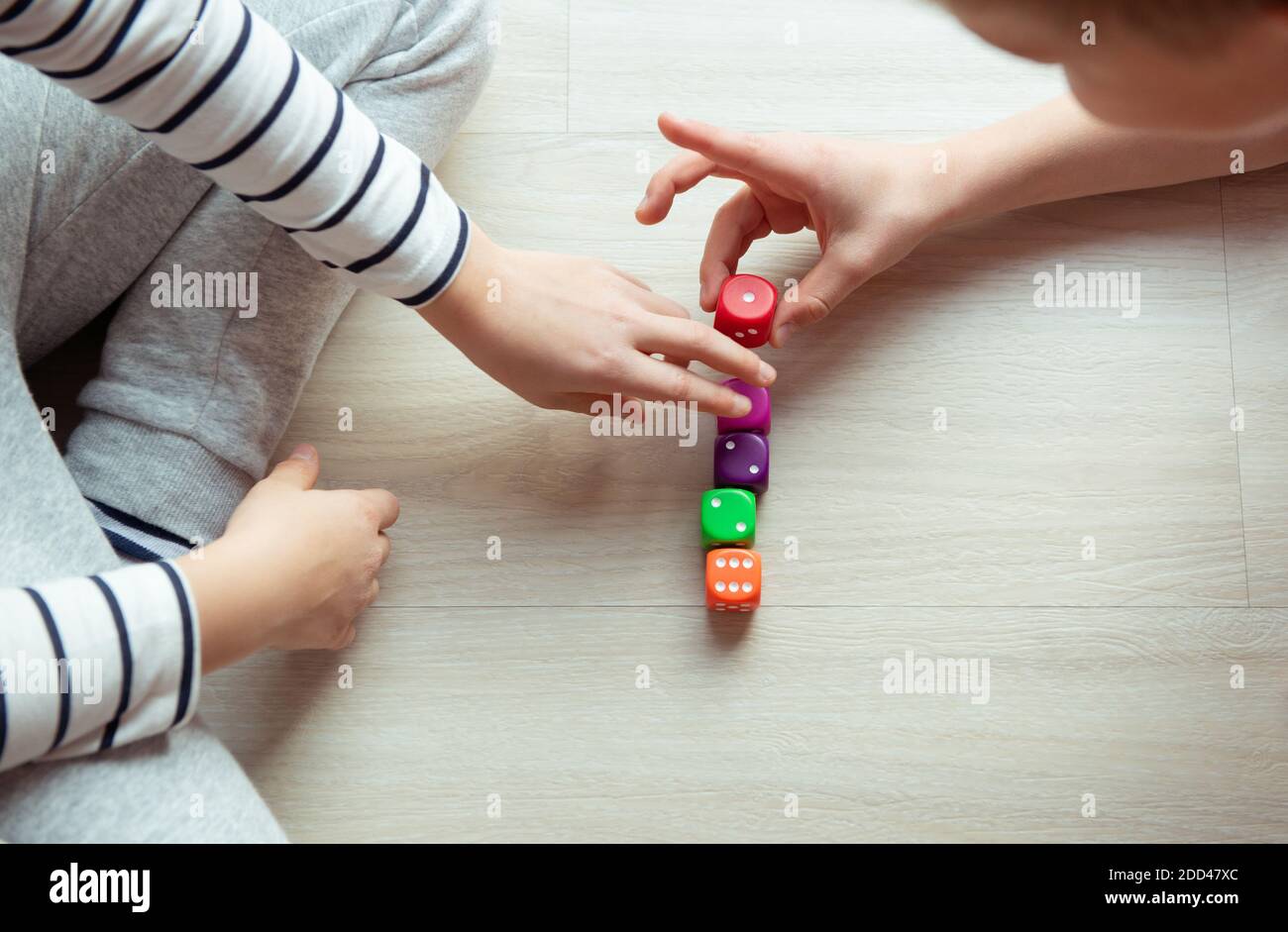 Two clever children study mathematics playing with colorful dices on ...