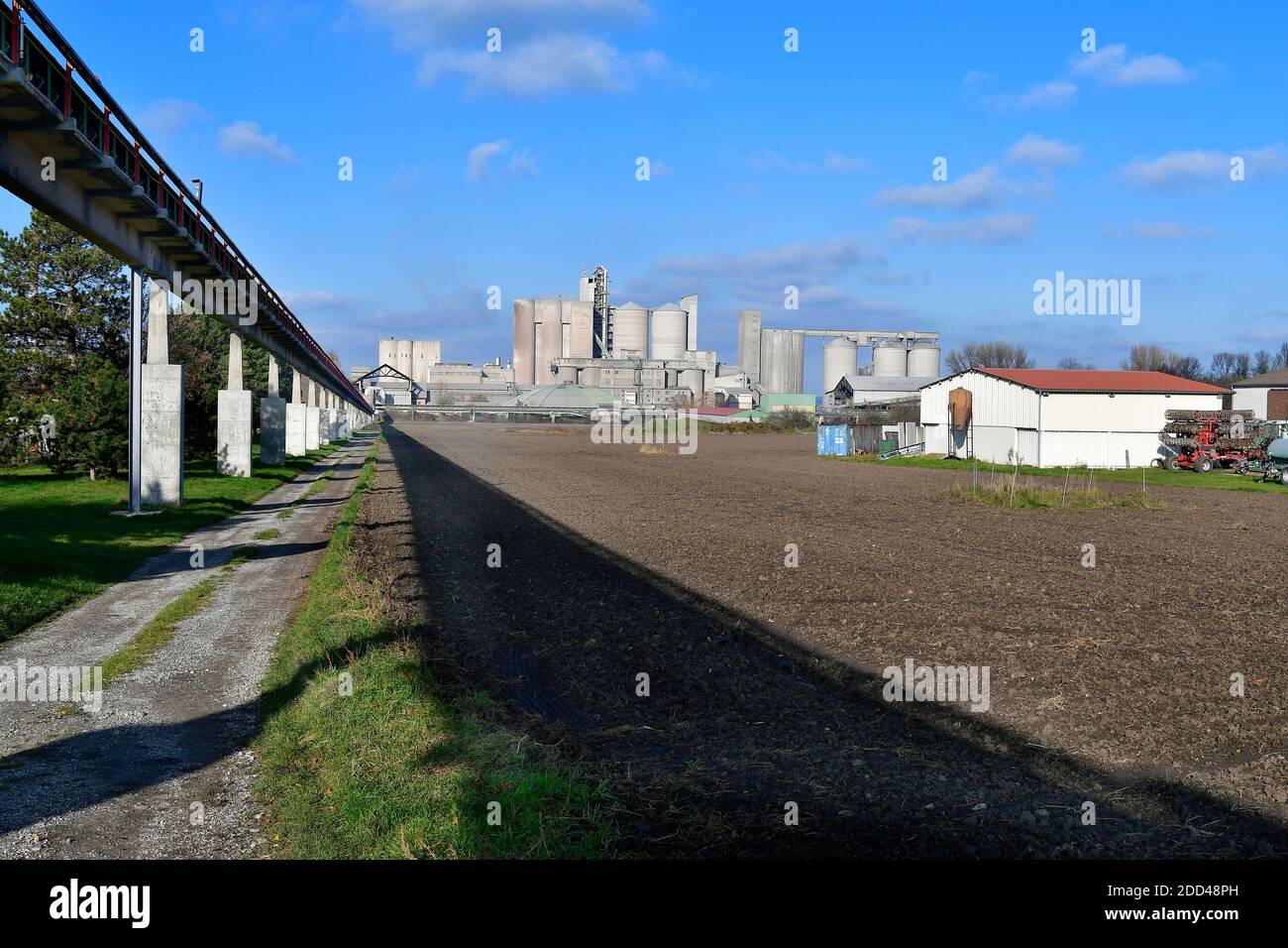 Austria, cement factory with conveyor belt and farmland in Lower ...