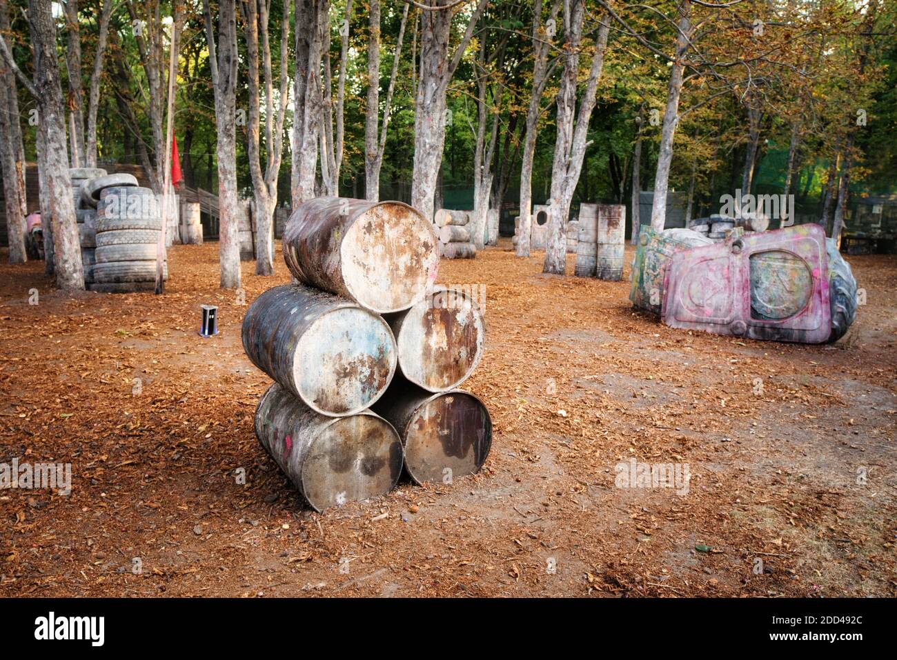 Old rusty barrels and damaged tires on a paintball base Stock Photo - Alamy