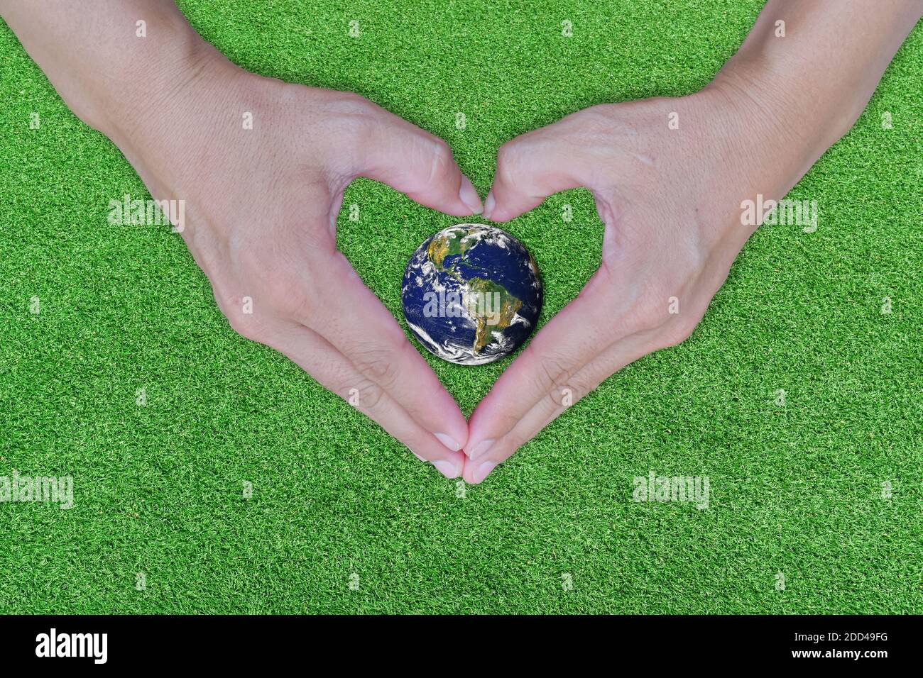 Earth day concept. Hands forming a shape heart with globe on green lawn ...