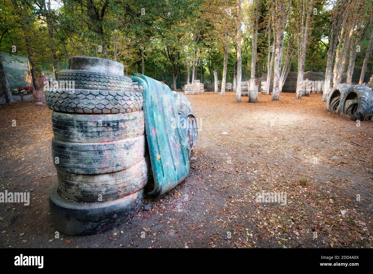 Old rusty barrels and damaged tires on a paintball base Stock Photo - Alamy