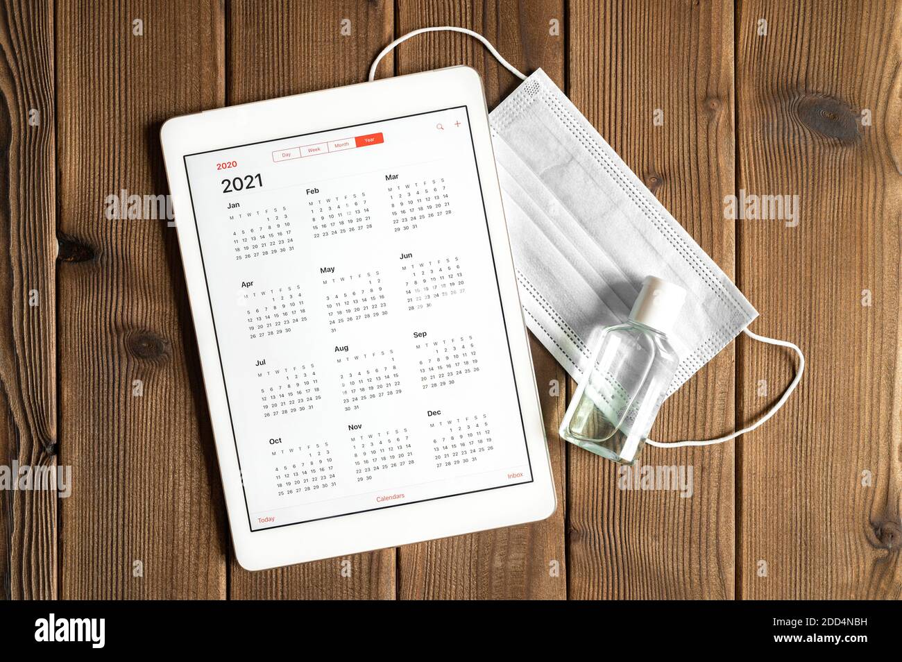 a tablet with an open calendar for 2021 year and protective medical ...