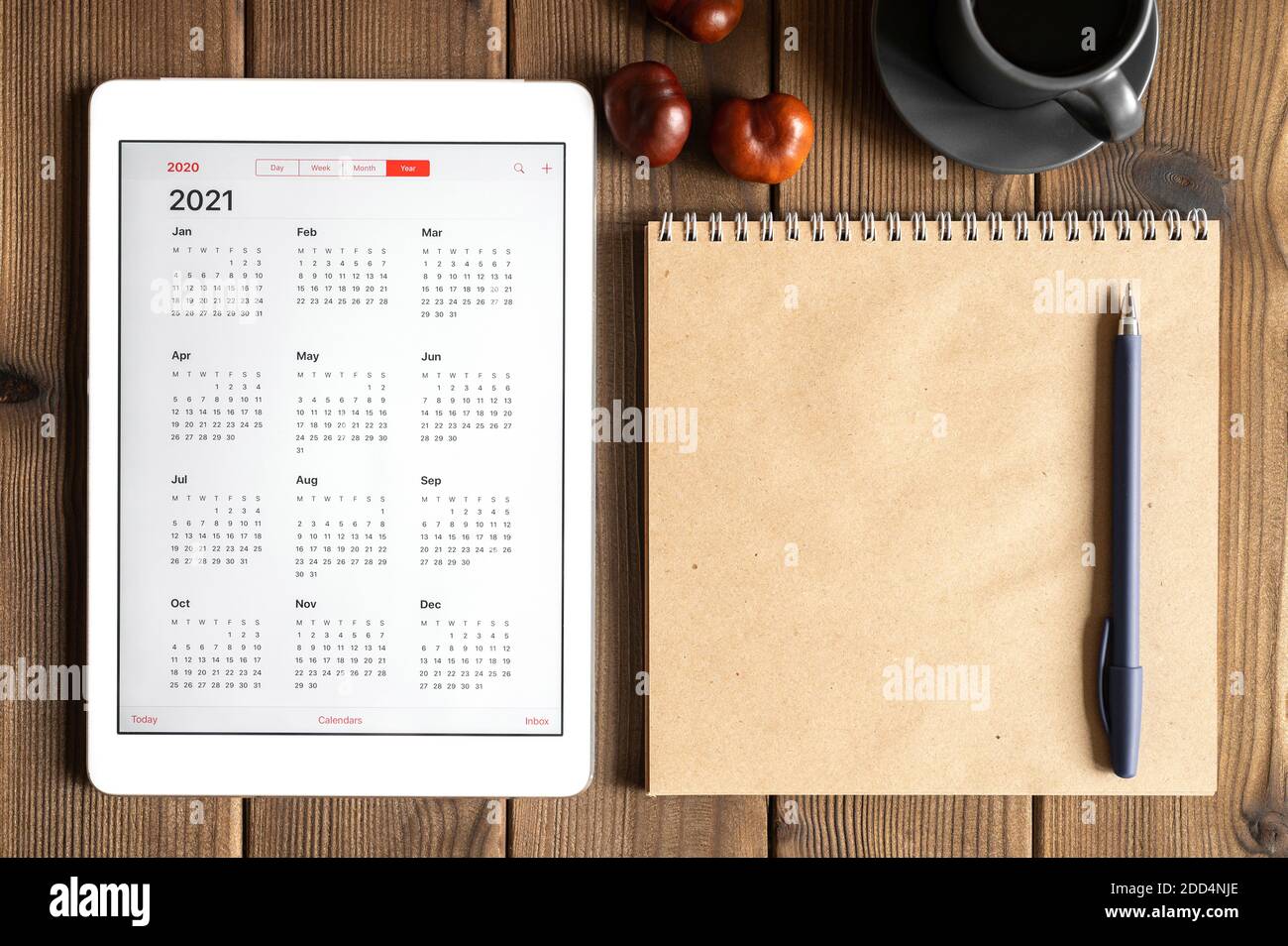 a tablet with an open calendar for 2021 year, a cup of coffee ...