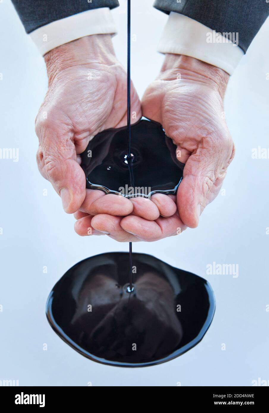 Man's cupped hands filled with black oil Stock Photo - Alamy