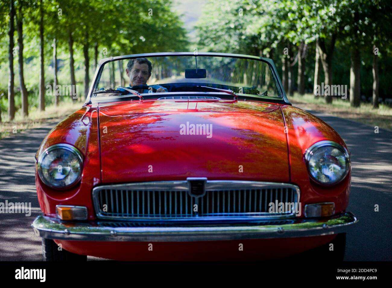Man driving red classic car Stock Photo - Alamy
