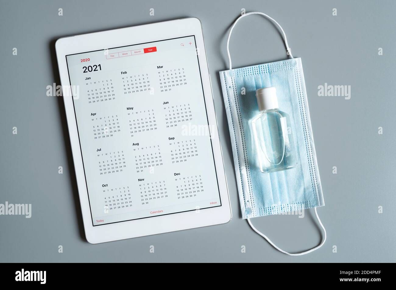 a tablet with an open calendar for 2021 year and protective medical ...
