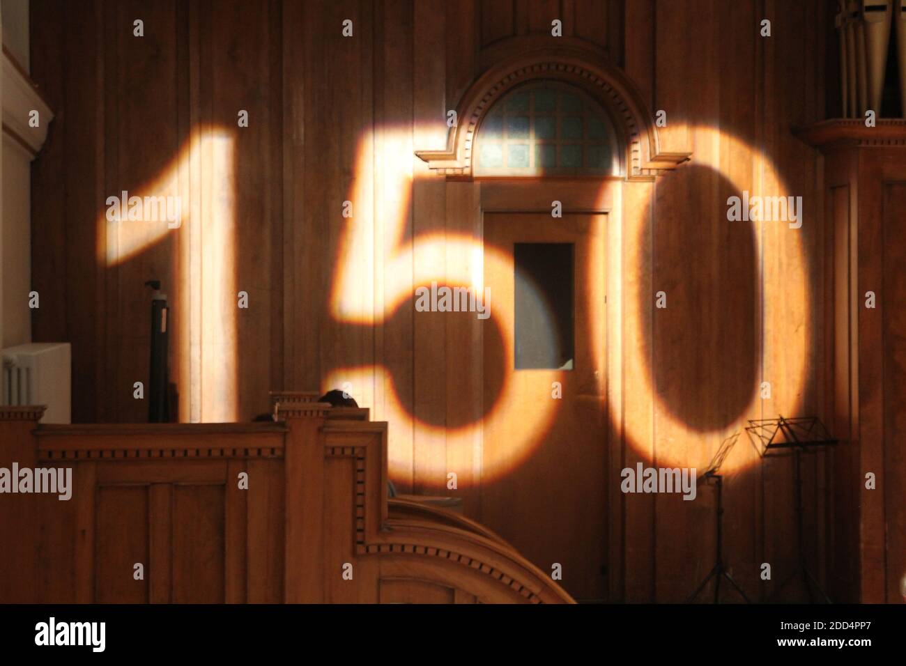 The number 150 projected onto a wood panelled wall Stock Photo - Alamy