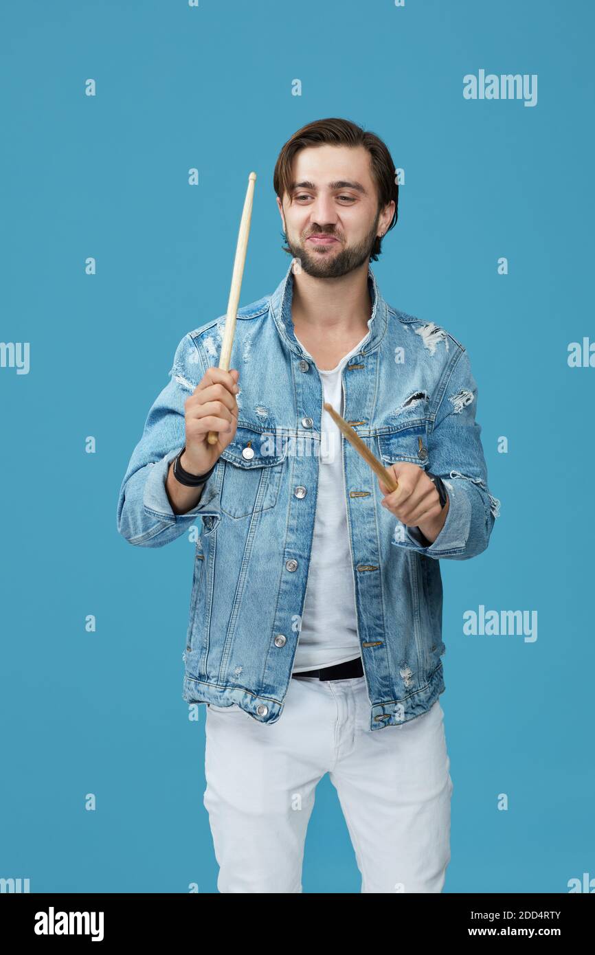 handsome male drummer improvising isolated on blue studio background ...