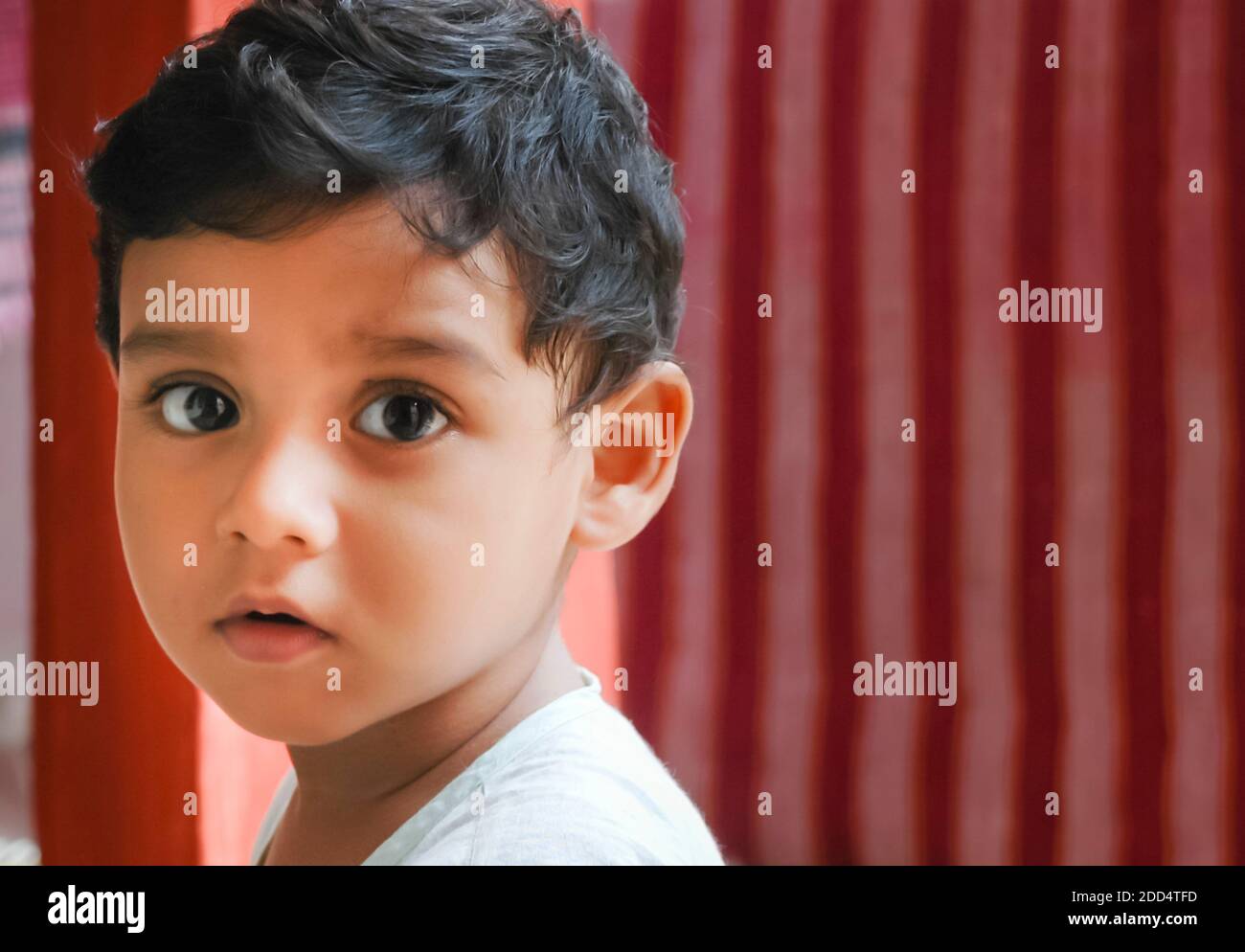 An Asian Indian baby looking at the camera with an expressionless face ...