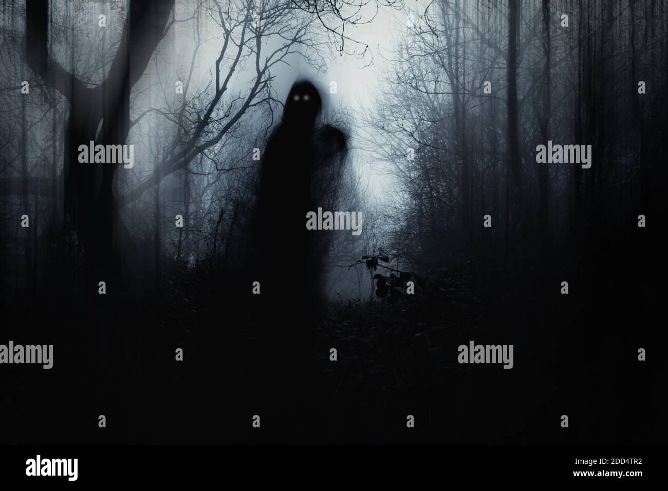 A scary hooded figure with glowing eyes in a spooky forest on a foggy ...