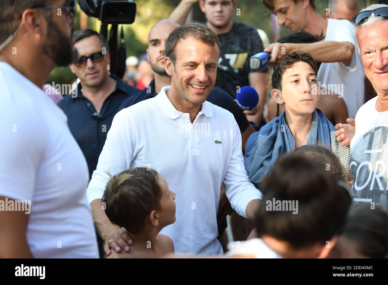 French President Emmanuel Macron meets people during a walk on August 7 ...