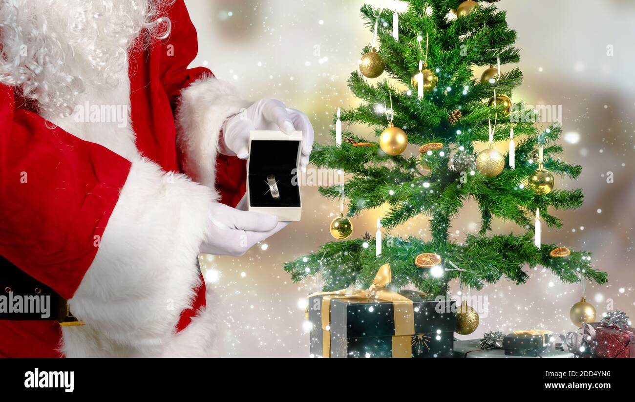 Santa claus is holding a jewelry case with a ring in his hand Stock ...
