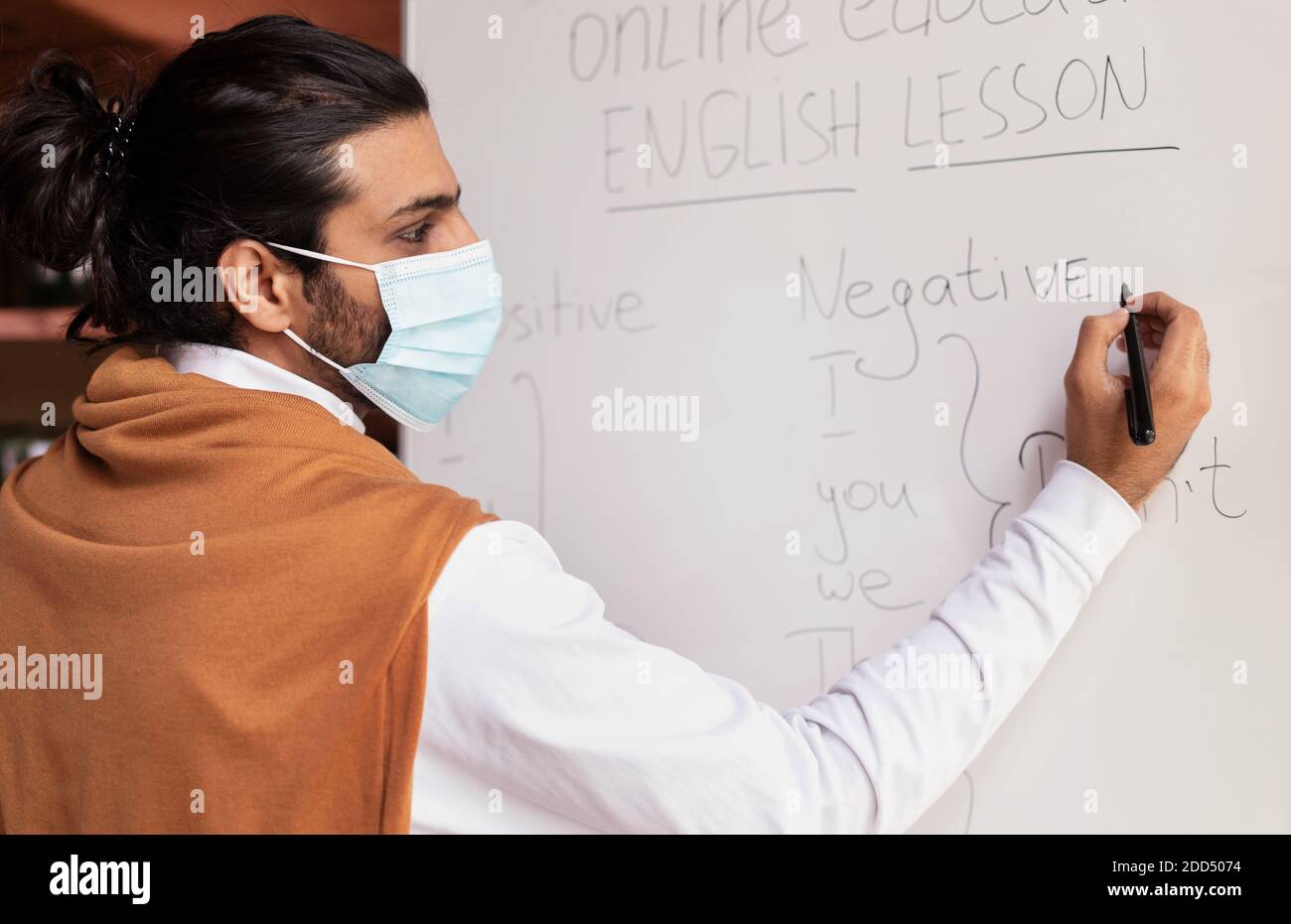 Teacher In Mask Teaching English Grammar Writing On Blackboard Indoors ...