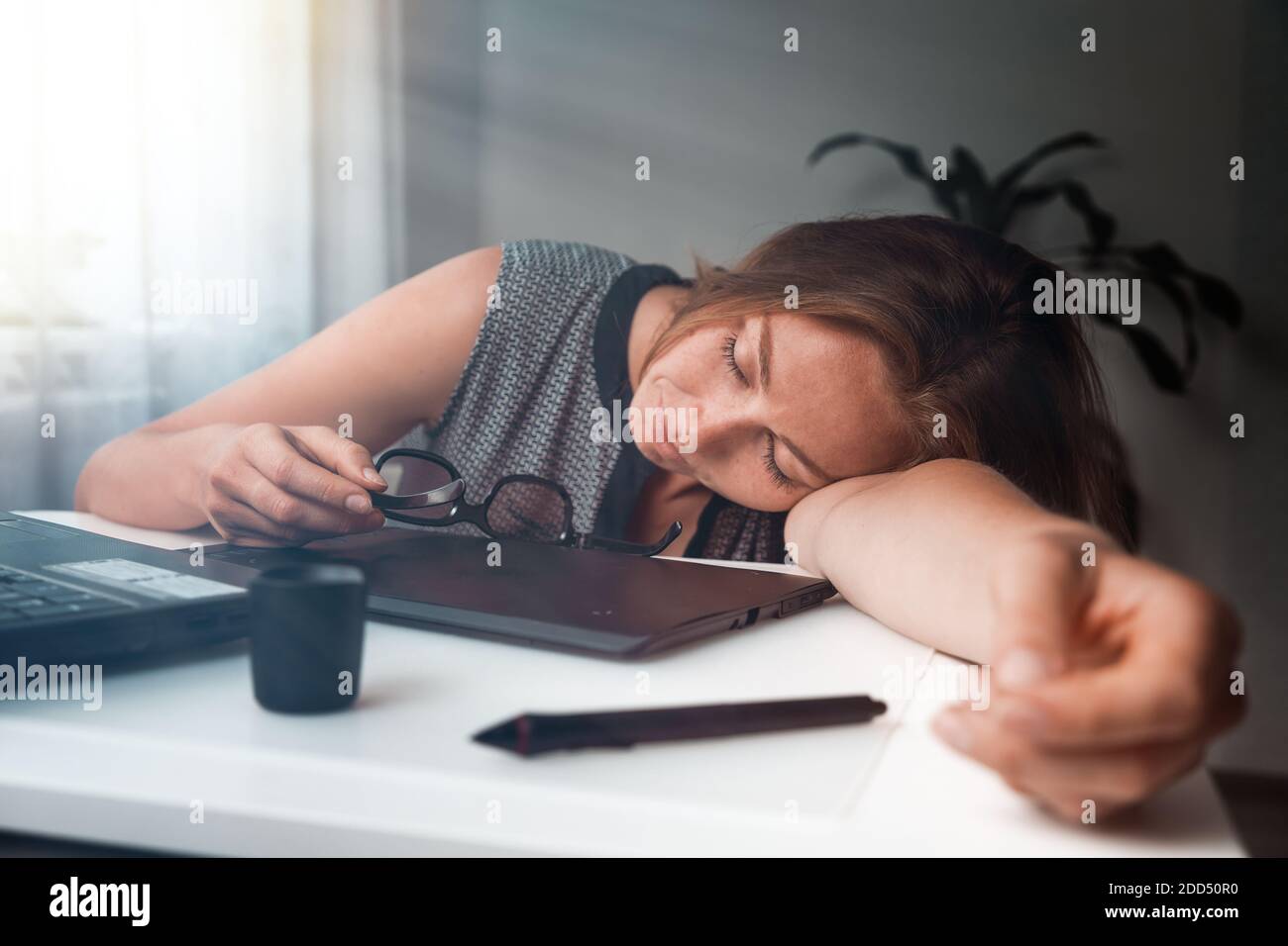 Young woman sleeping in the workplace. Fatigue and overload in office ...