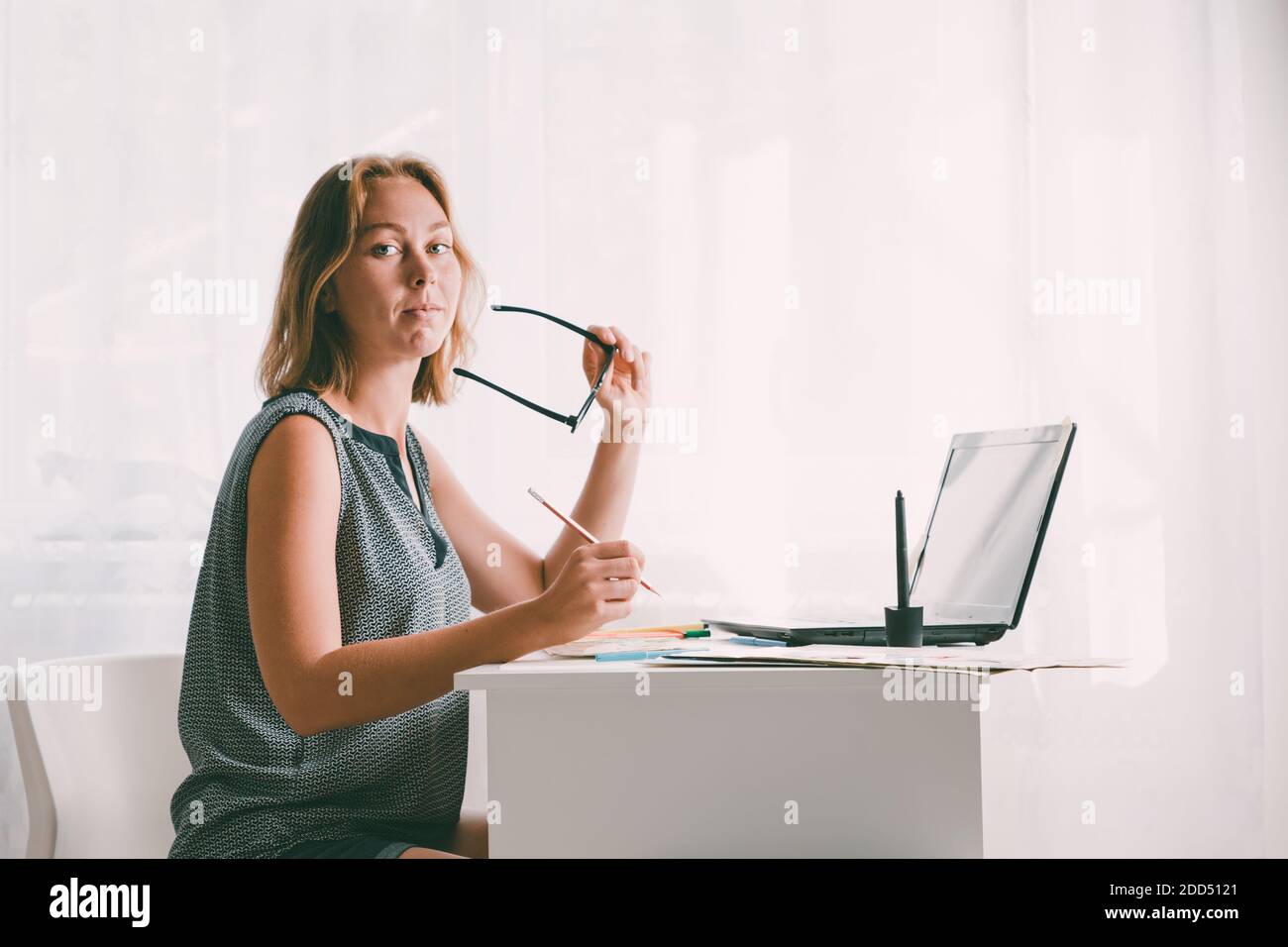 Creative and office work. Young woman designer working at a computer ...