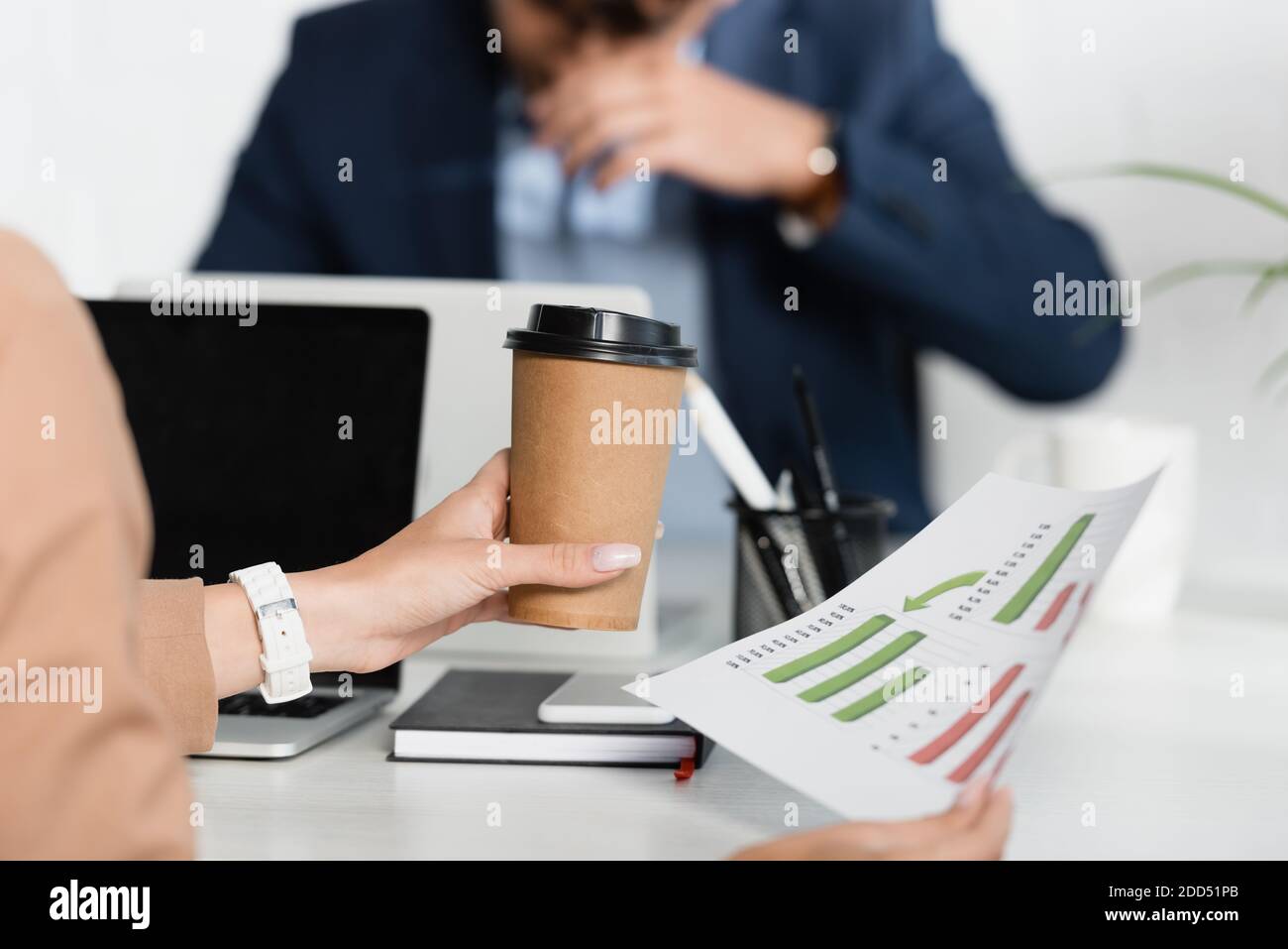 Cropped view of businesswoman with paper cup, holding paper sheet with ...