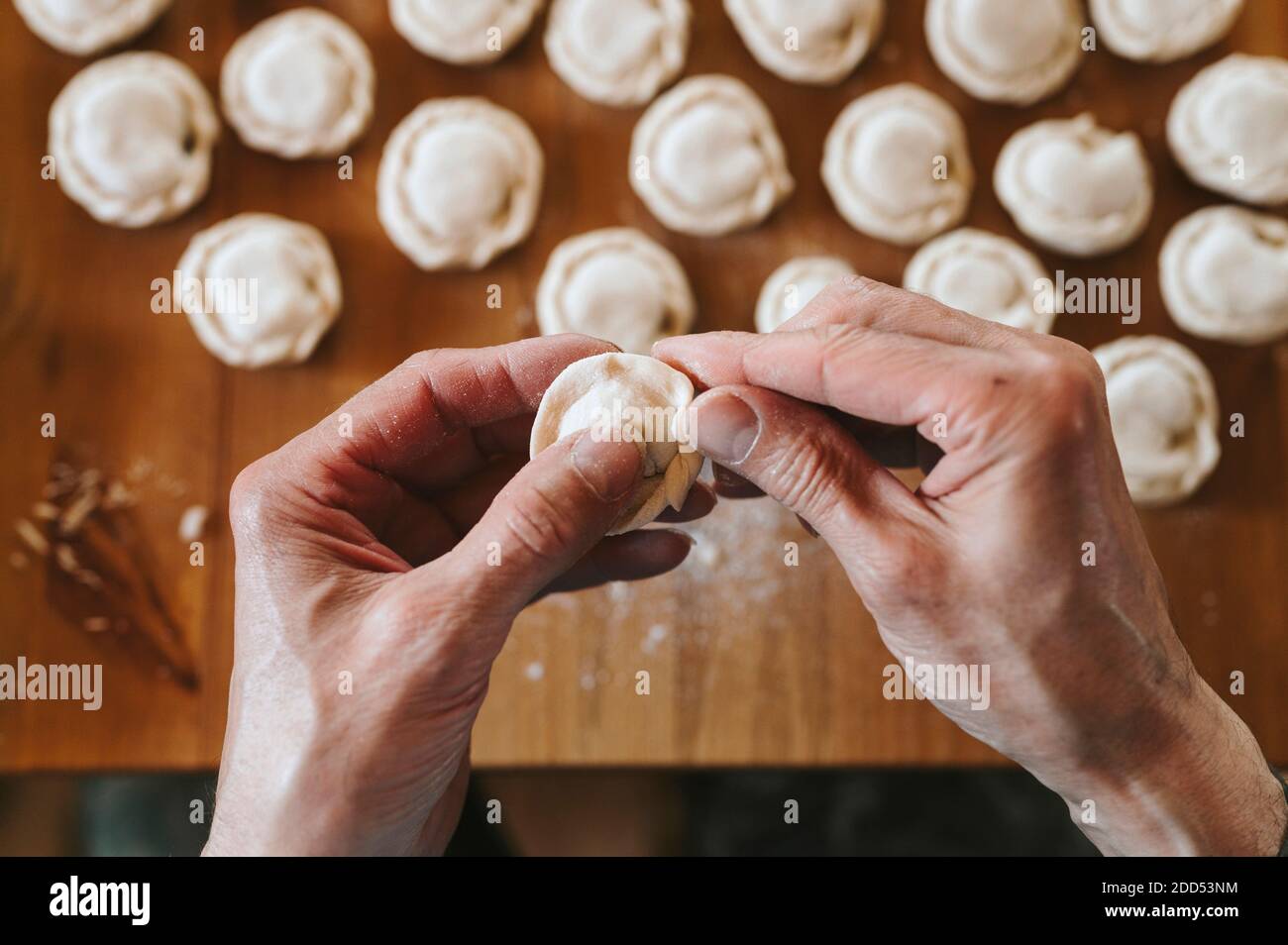 hands of senior man cooking and molding small homemade uncooked ...
