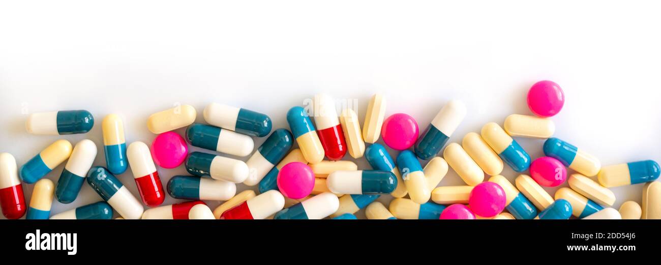 Colorful pills and medication on panoramic white background with copy ...
