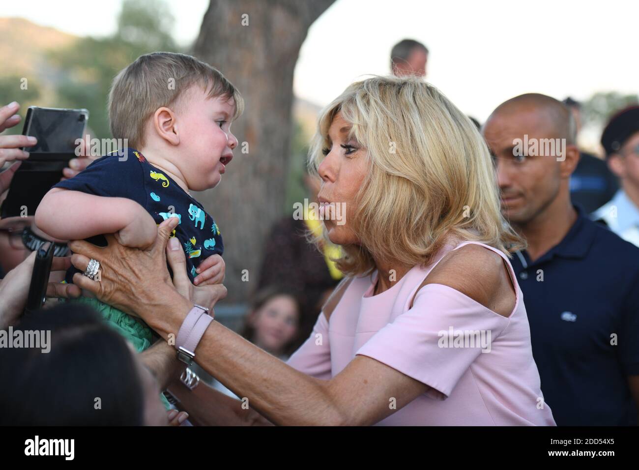 Brigitte Macron is carrying a little boy after marking the 74th ...