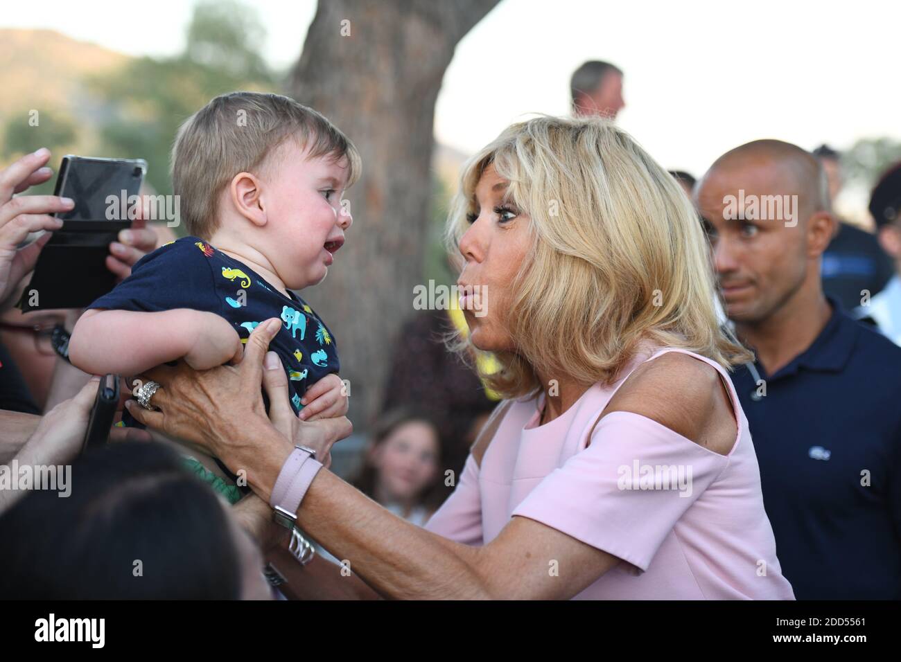 Brigitte Macron is carrying a little boy after marking the 74th ...