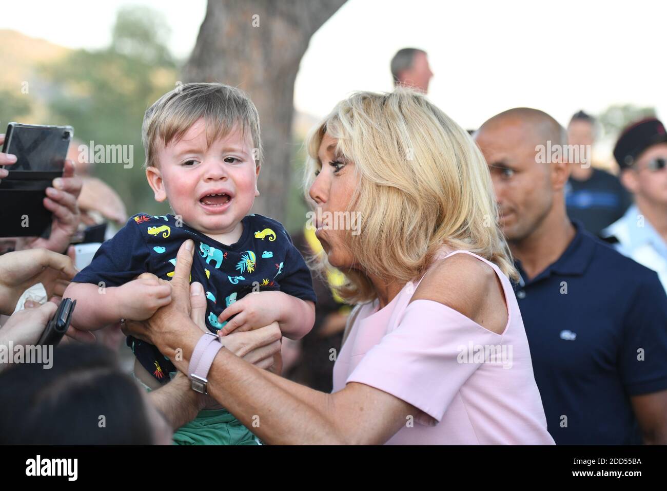 Brigitte Macron is carrying a little boy after marking the 74th ...