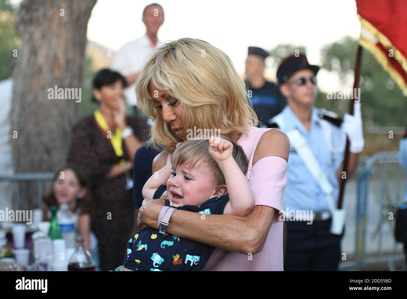 Brigitte Macron is carrying a little boy after marking the 74th ...