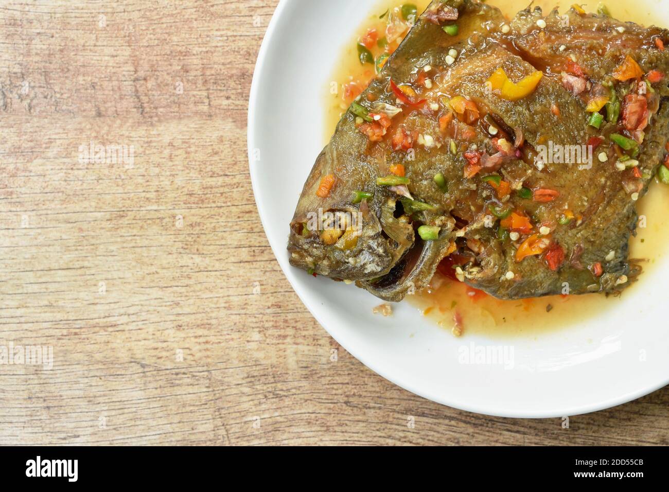 deep fried white pomfret dressing spicy sauce on plate Stock Photo - Alamy