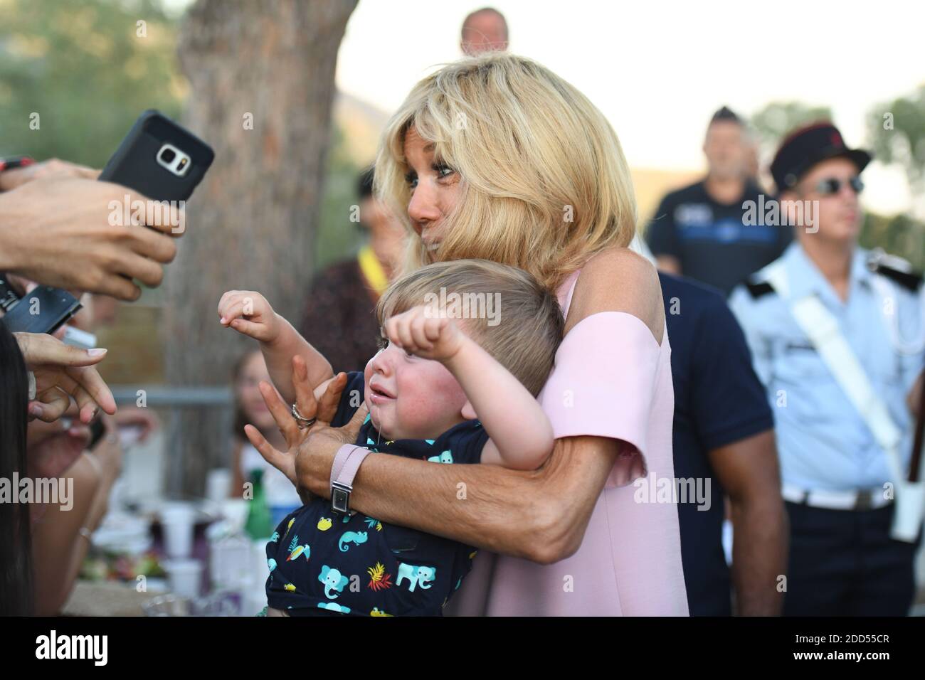 Brigitte Macron is carrying a little boy after marking the 74th ...