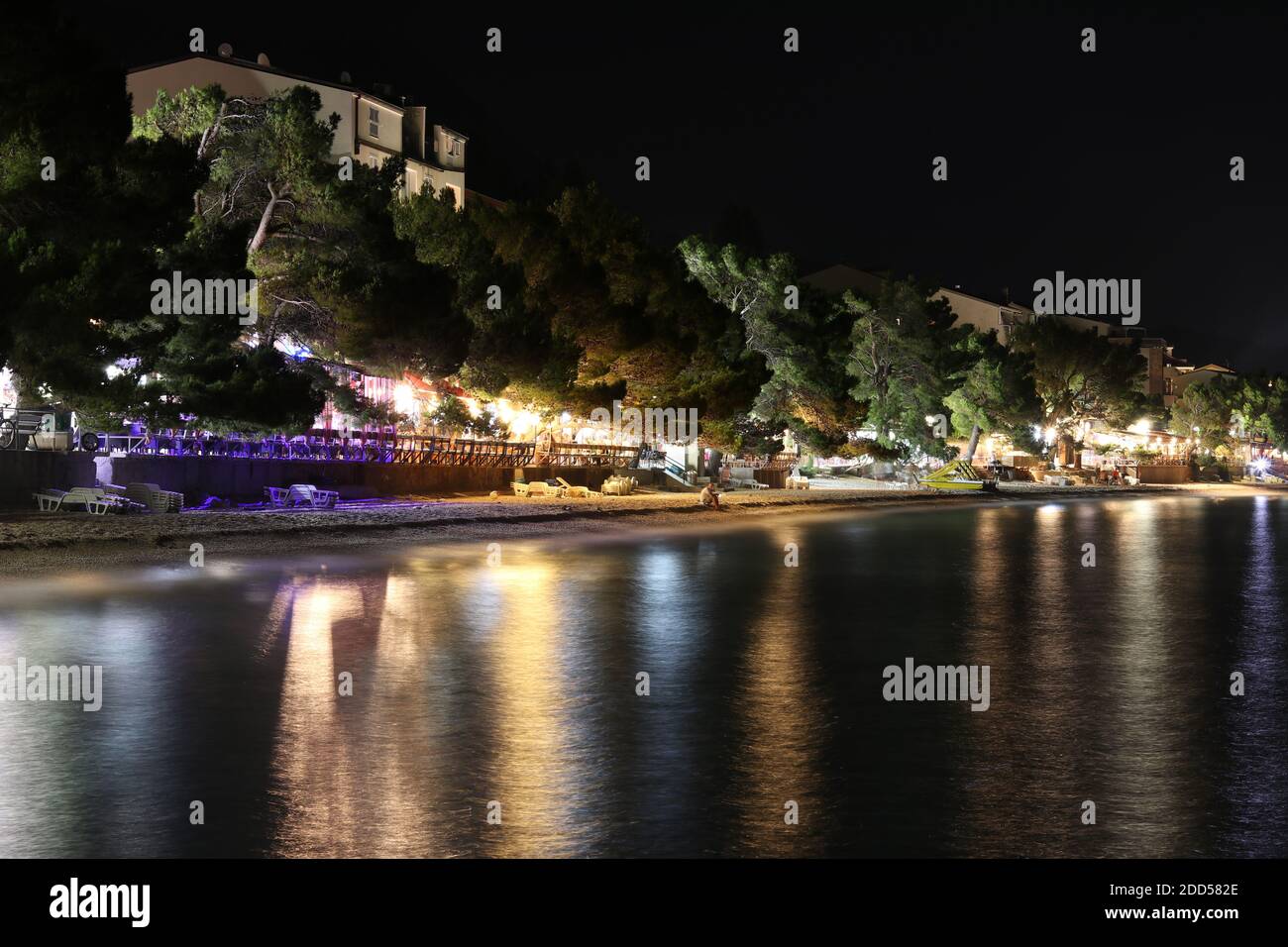 View of an iluminated beach and sea with still water at night Stock ...