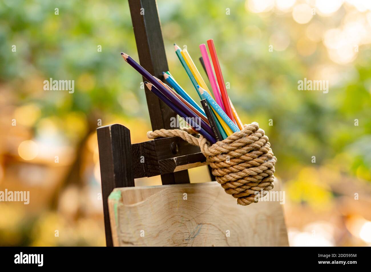 Colored pencils tied with a rope in garden for kid zone Stock Photo - Alamy