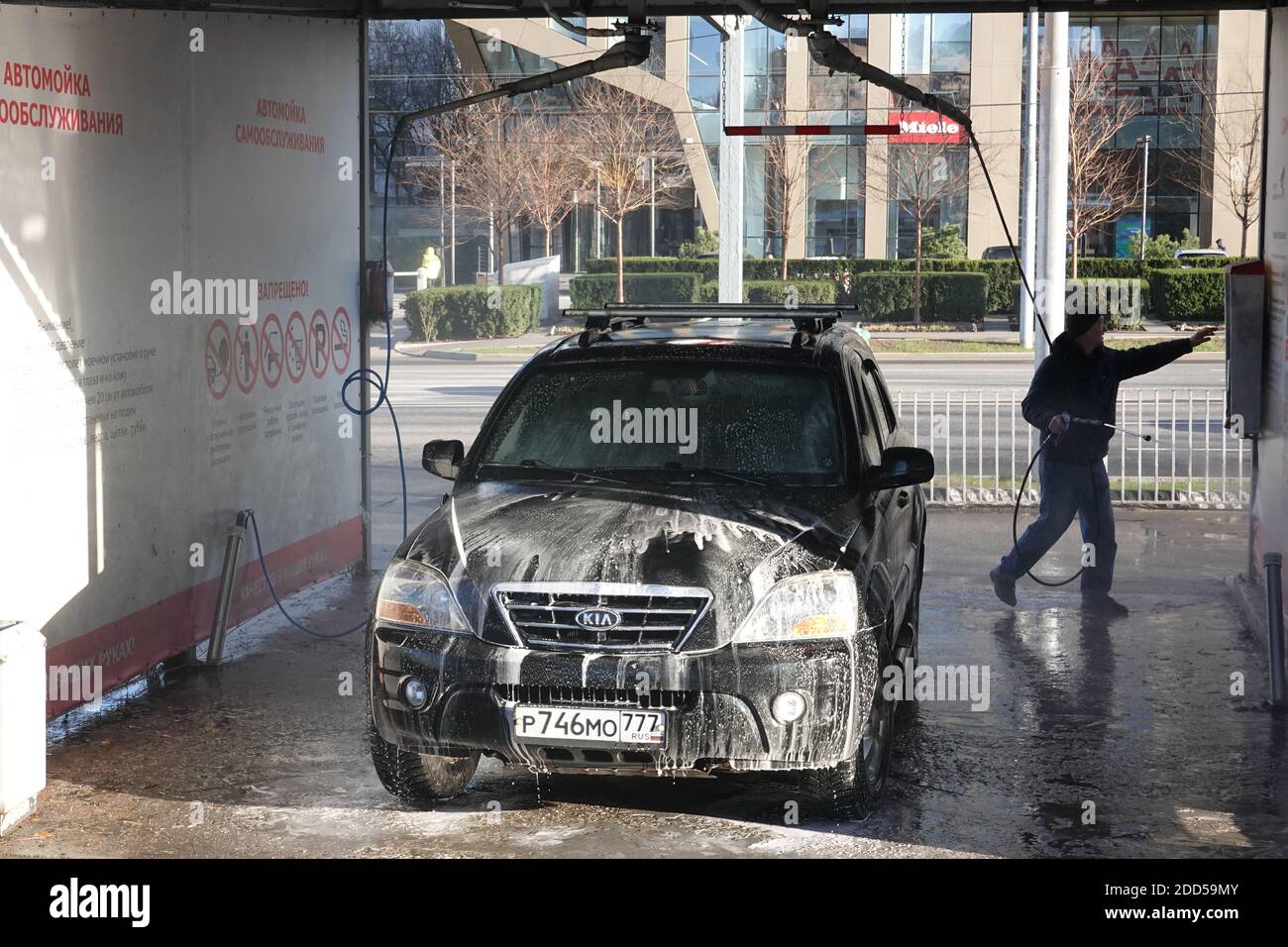 Driver washing car at self-service car wash Stock Photo - Alamy